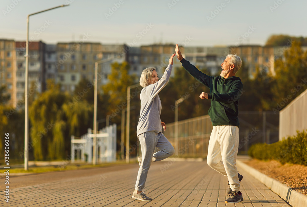 Active senior happy pair running high five, sporty physically energetic ...
