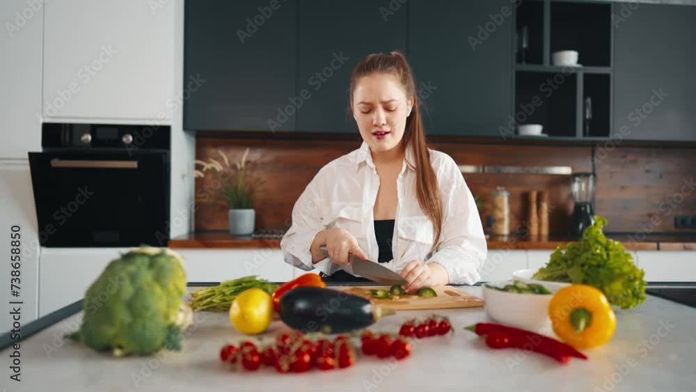 Young woman cooking, dancing at kitchen. Girl cook healthy food listen ...