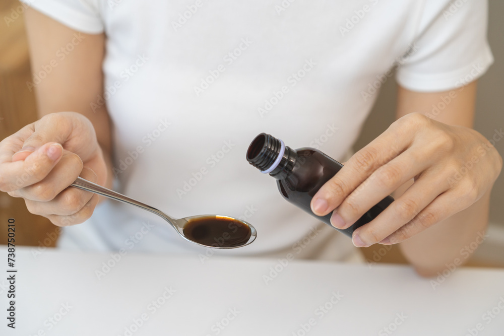 Close up hand of sick woman pouring syrup, liquid antipyretic, cough ...