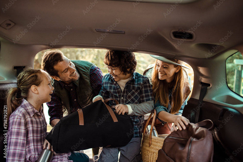 Family road trip packing car trunk with smiling children and parents ...