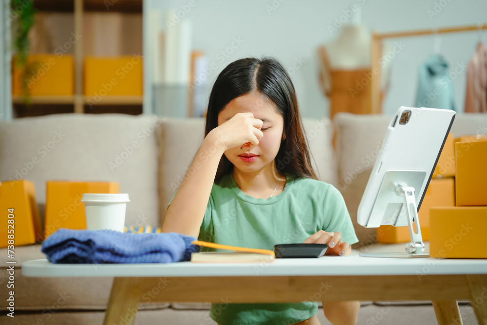 young Asian SME owner of a clothing store faces stress and sadness due ...