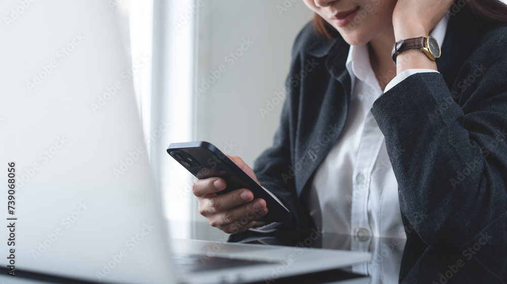 Young smiling asian businesswoman using and looking at mobile phone ...