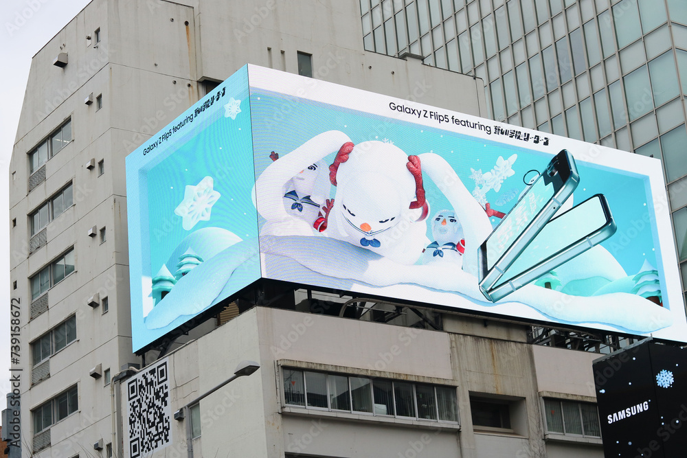 TOKYO, JAPAN - February 17, 2024: A multi-screen billboard with an ...