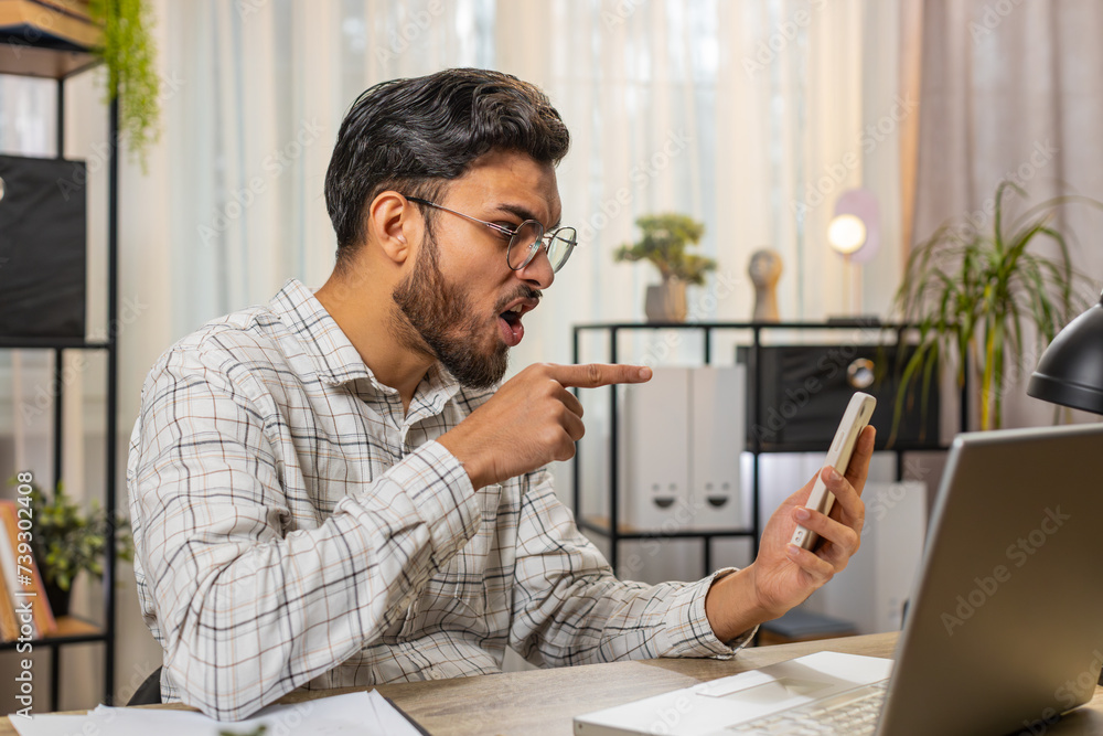 Quarrel. Furious annoyed Indian businessman freelancer engage in heated phone conversations at ...