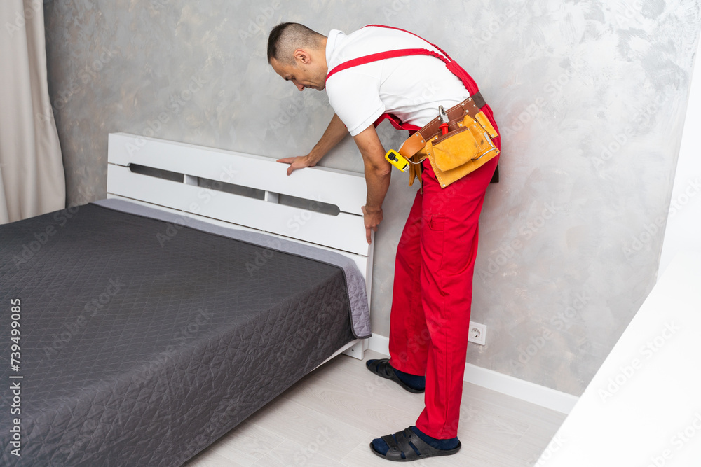 Man furniture maker assembles bed. Process production interior items ...