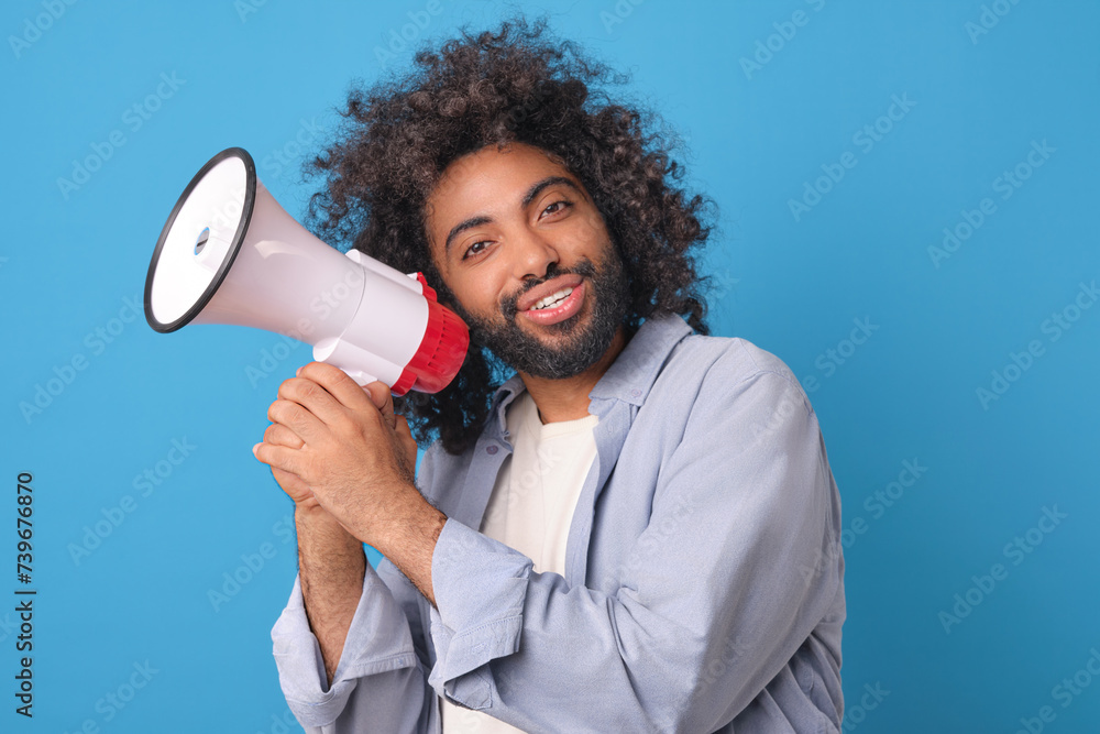 Young smiling attractive Arabian man promoter holds white megaphone in ...
