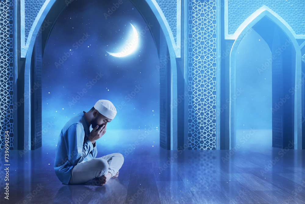 Young asian muslim man with beard praying in the mosque door arch at ...