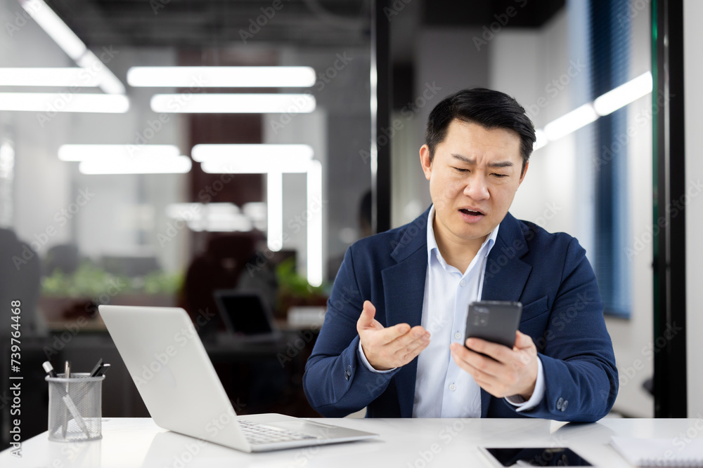 Sad disappointed asian man at workplace, dissatisfied employee in ...