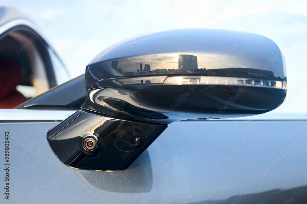 Luxury car detail left back mirror two parking cameras closeup. Road ...
