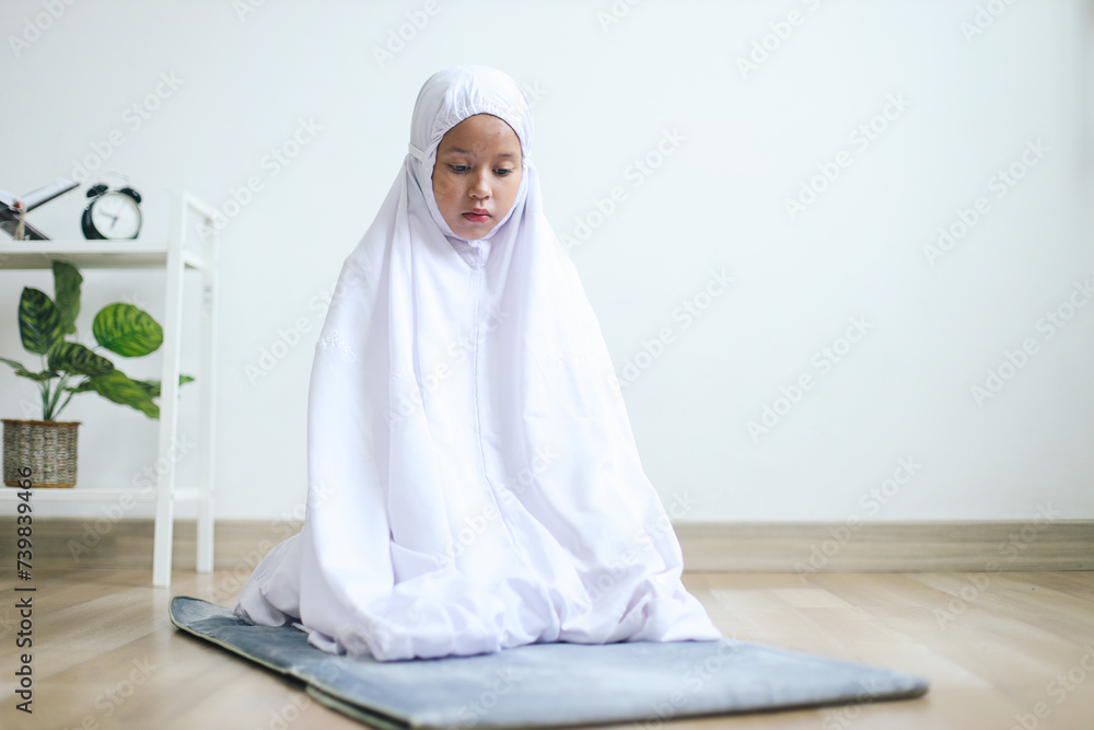 Asian Muslim little girl doing one of movement gesture in salat ...