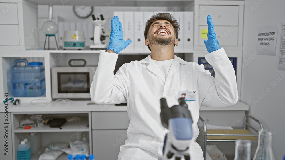 Foto de Victorious young arab man, a beaming scientist, revels from ...