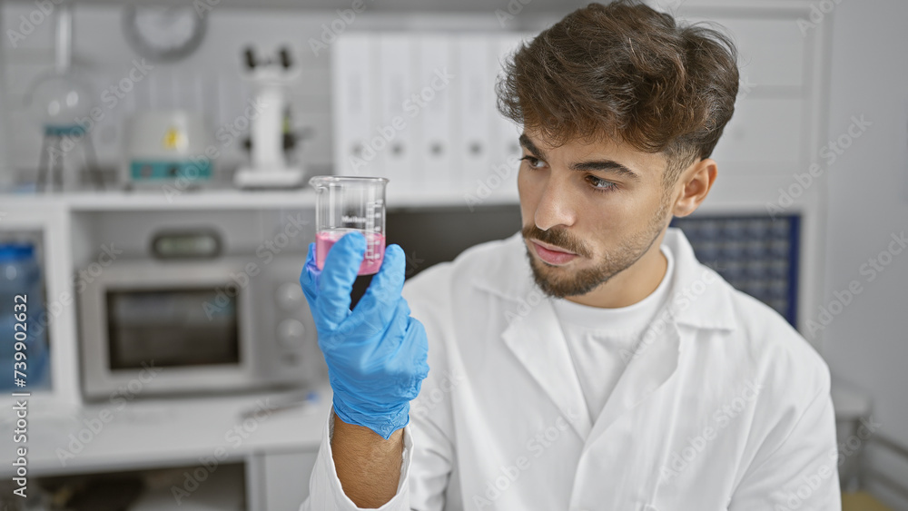 Serious young arab man scientist in lab, hands-on with test tube ...