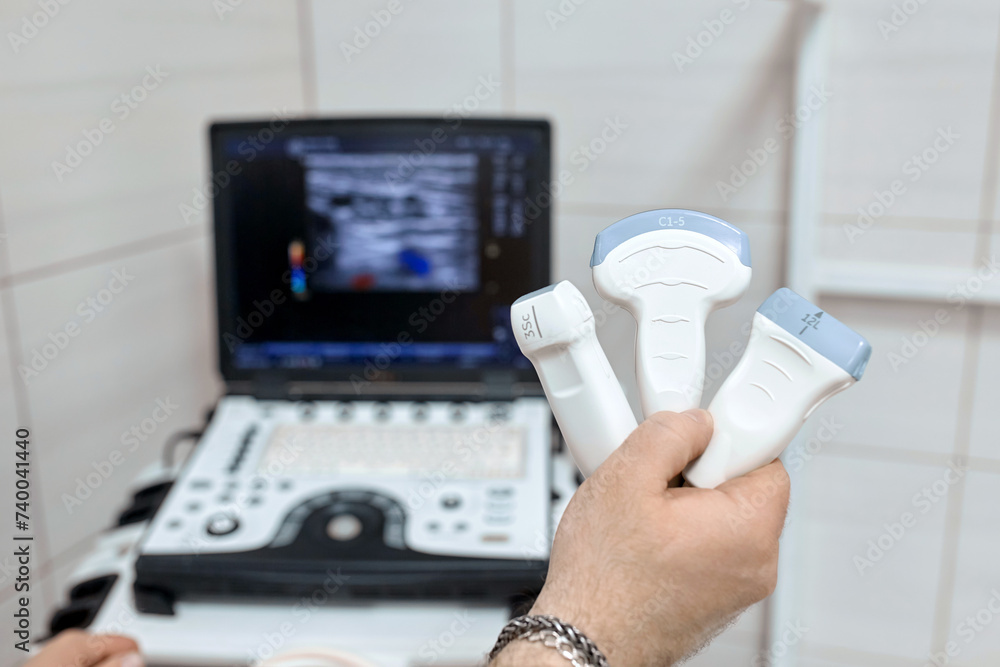 Close-up of ultrasound diagnostic probe. A doctor's hands hold a ...
