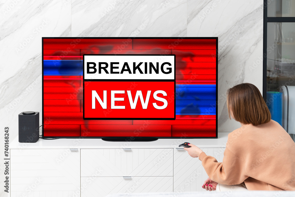 Back view on excited man sitting on the couch and watching breaking ...