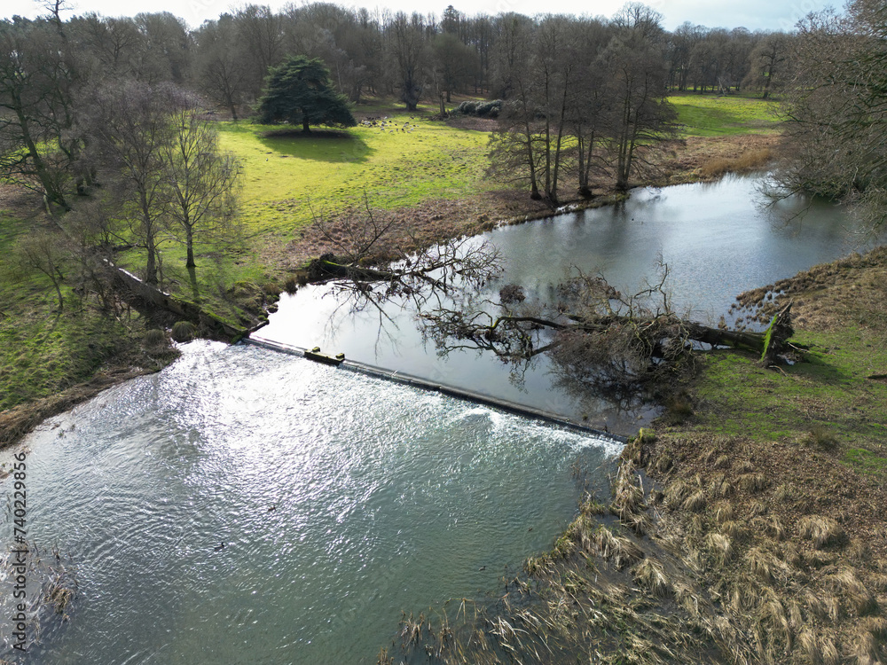 Pair of fallen mature trees seen laying in a fast moving river in the ...