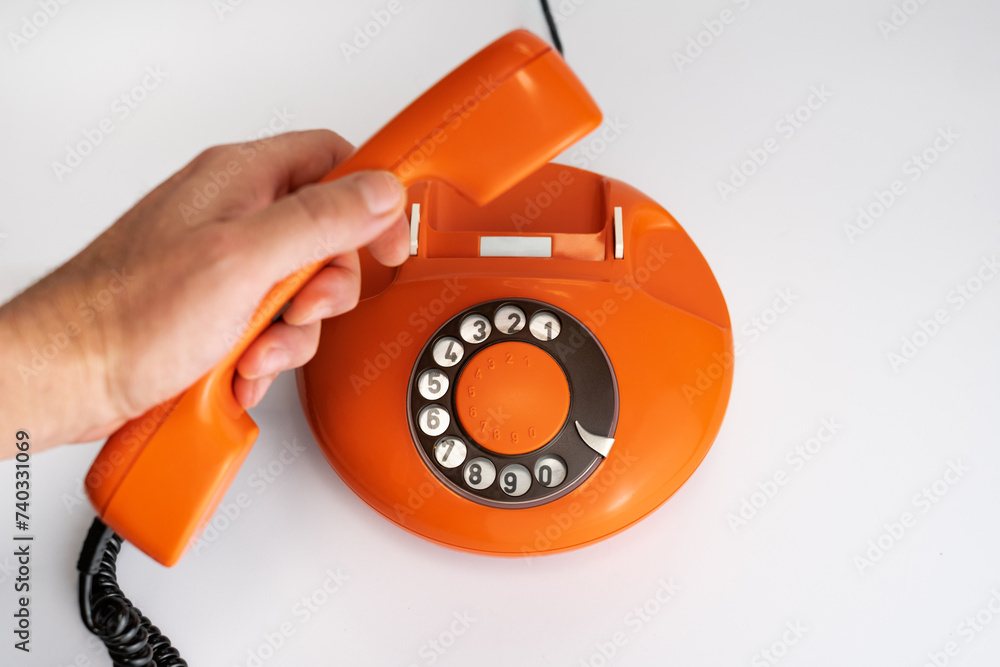 Dialing Using rotary Disk on A vintage Orange color Rotary Phone. Land ...