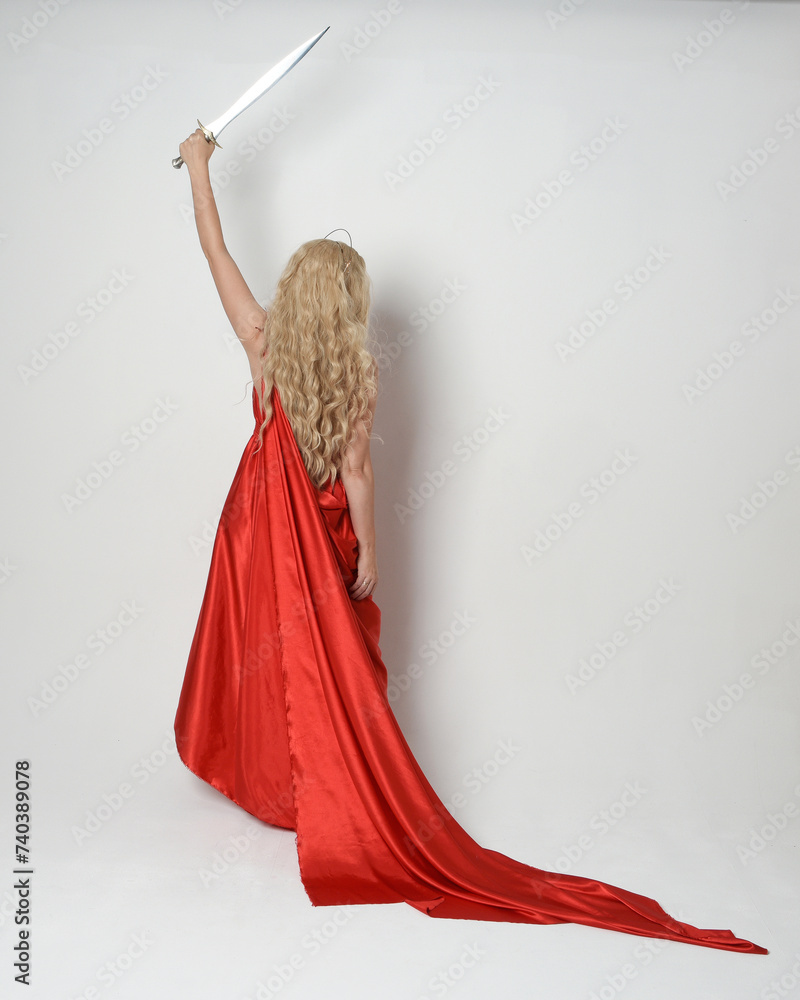 Full length portrait of beautiful blonde model dressed as ancient ...