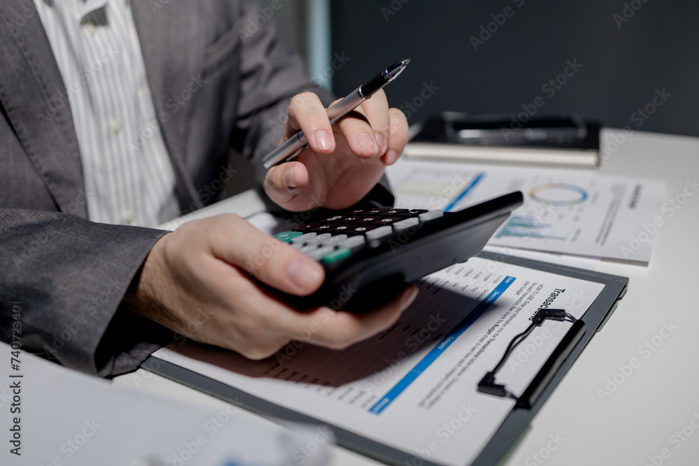 An employee is seriously calculating numbers in an important document ...