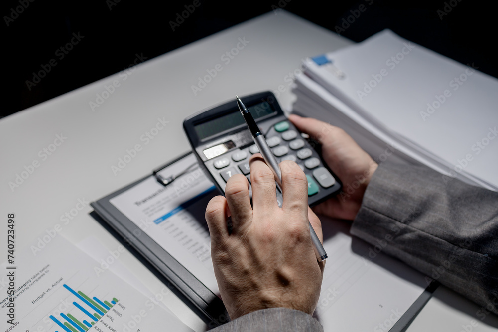 An employee is seriously calculating numbers in an important document ...