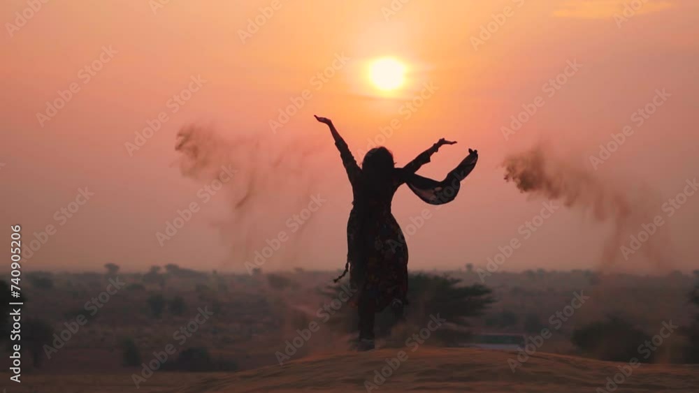 Silhouette shot of Desert sand falling from hands of girl with arm ...