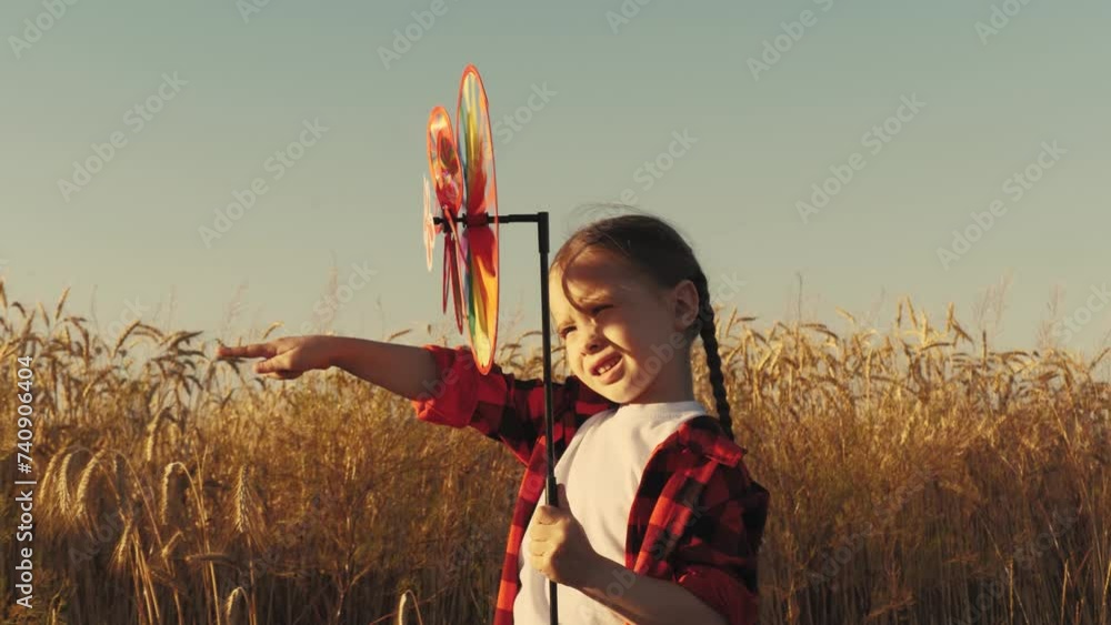 Happy little girl runs across field park sunset, holding toy windmill ...