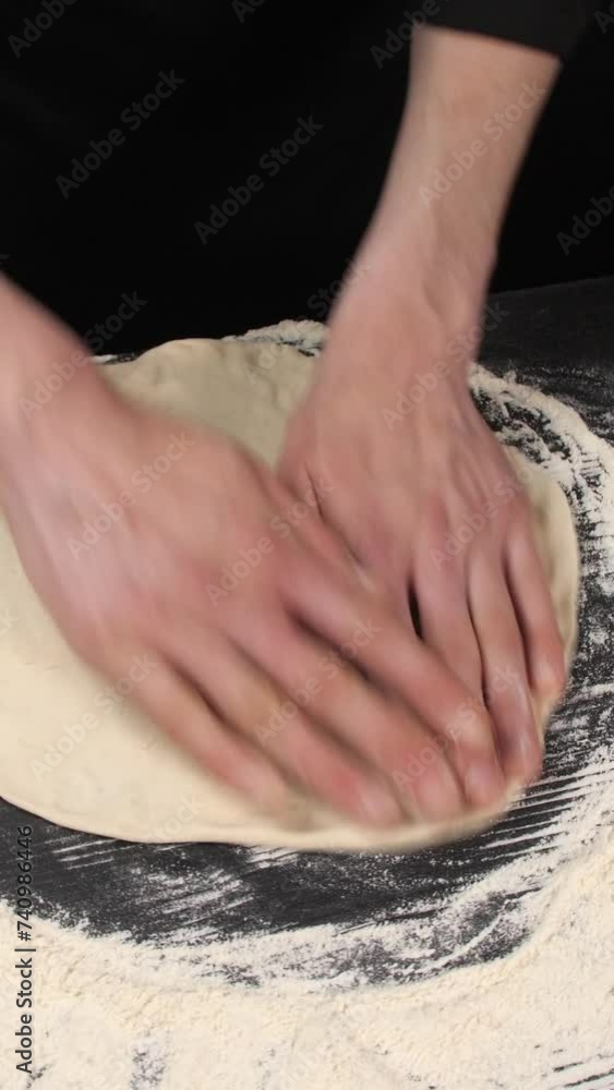 Vertical video. Cooking Italian pizza in a restaurant. Stretching raw ...