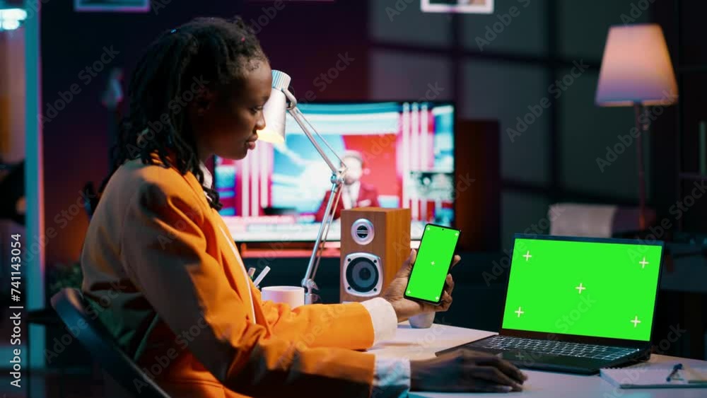 African american girl uses smartphone and pc with greenscreen, looking ...