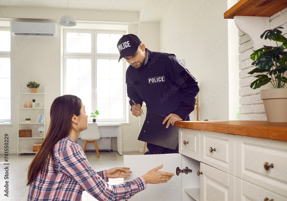 Police officer communicating with victim of burglary. Woman house owner ...