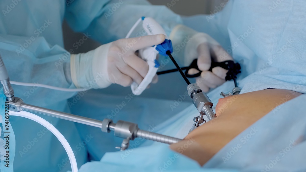 Operating room, team of surgeons performing laparoscopic intervention ...