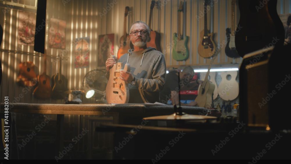 Mature carpenter, craftsman stands in modern woodworking workshop ...