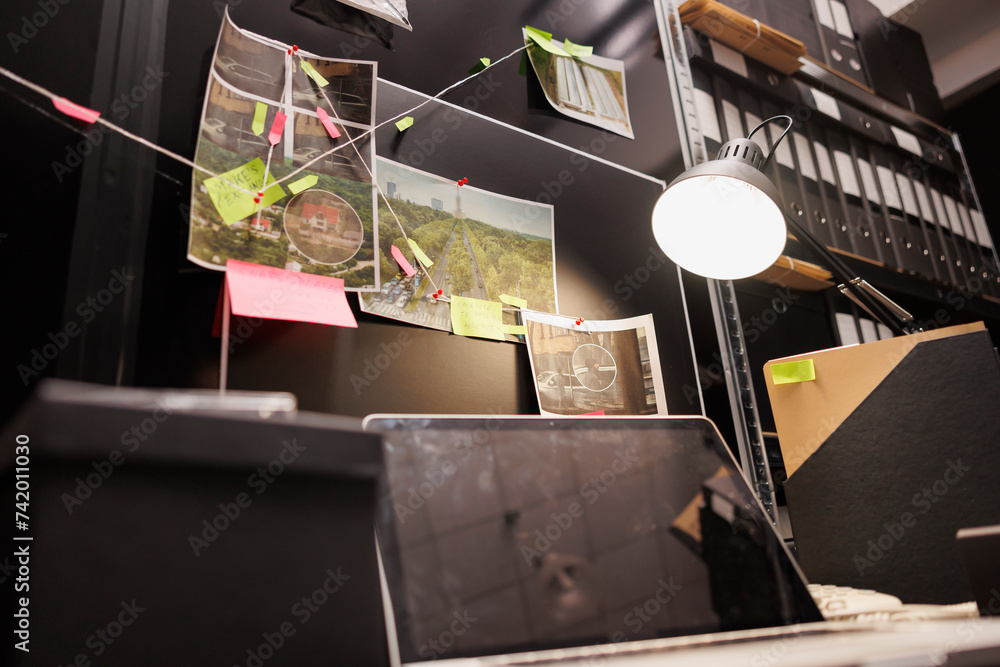 Crime scene photos attached to detective board over table in ...