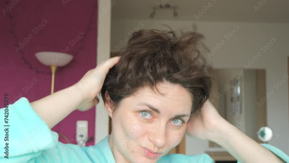 Portrait of a young woman looking into the camera and touching and ...