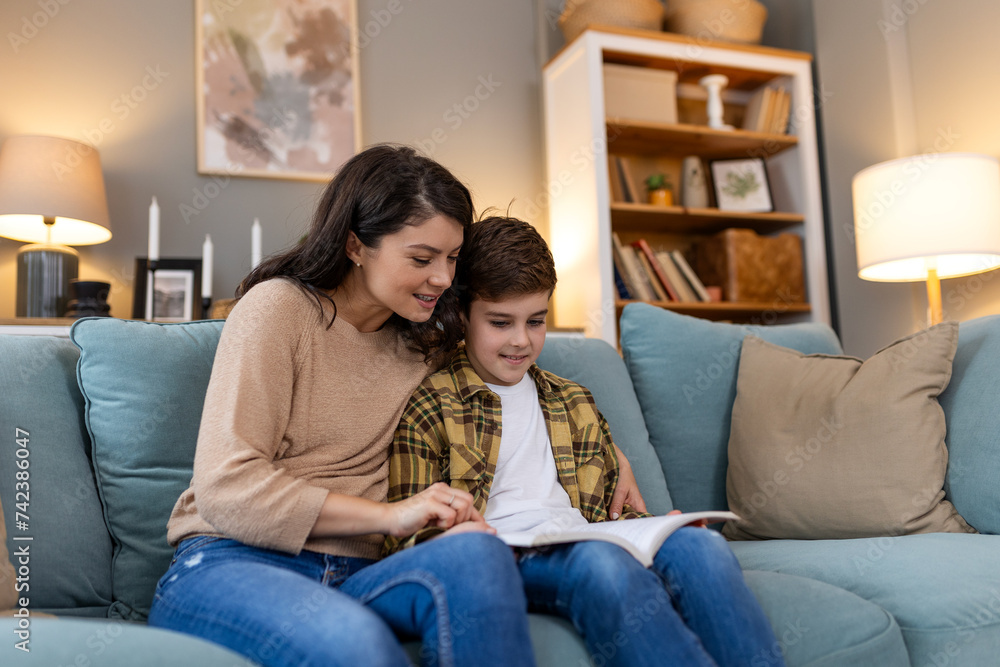 Loving young mother reading book to adorable little son, sitting on ...