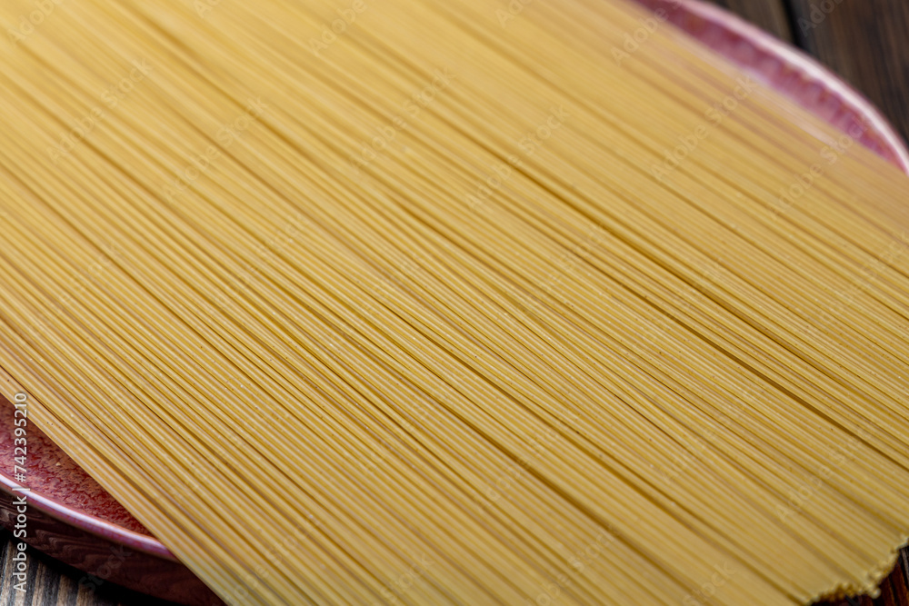 Yellow long spaghetti on a rustic background. Yellow italian pasta ...