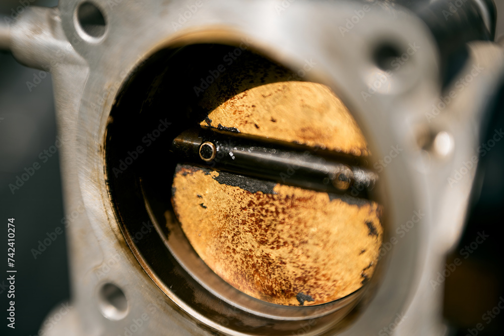 carbon deposits damage a throttle valve of a car engine. The valve ...