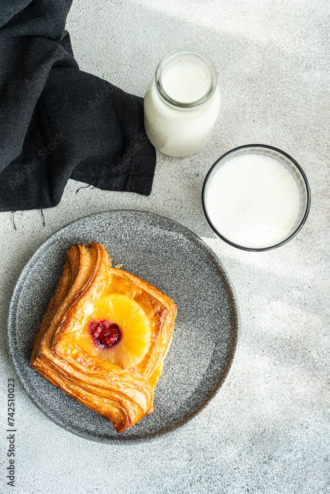 Overhead view of a sweet pineapple pastry with a glass and bottle of ...
