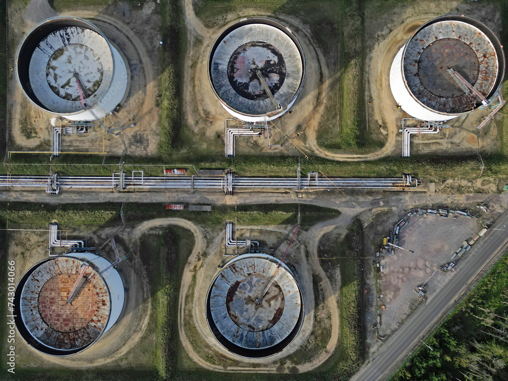 Five oil storage tanks in line top down aerial. A group of white oil ...