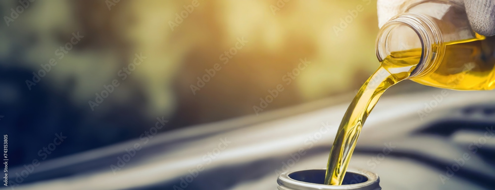 Golden motor oil flows into a car's engine. Luminous liquid is being ...