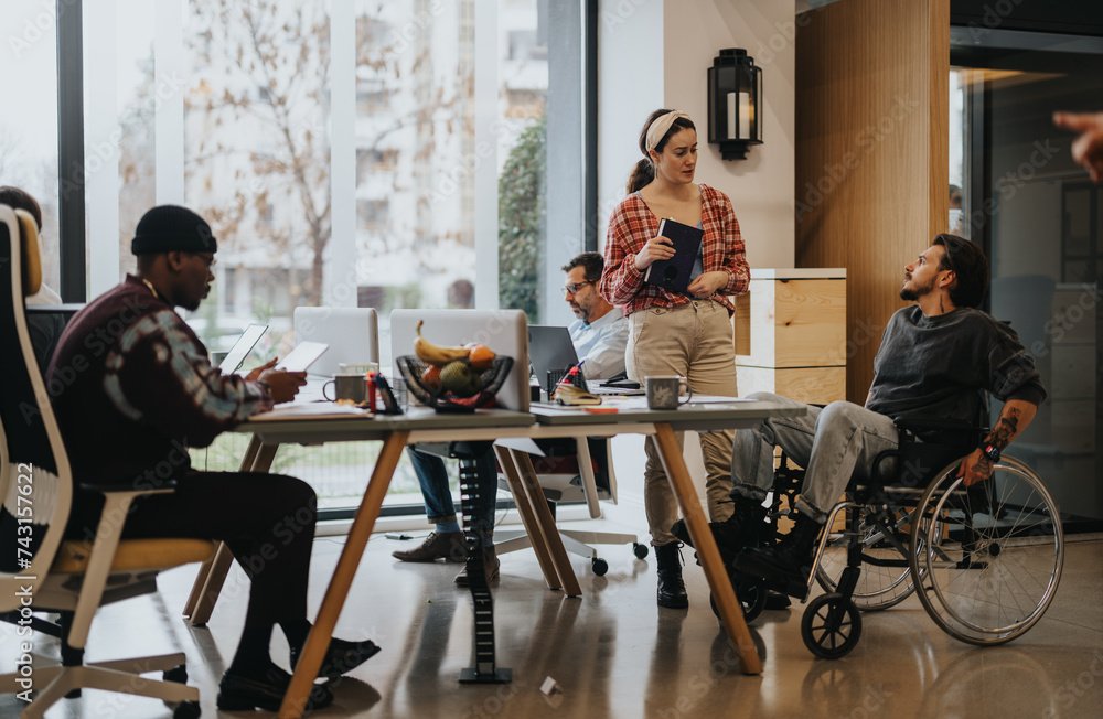 Diverse office team working and communicating in an accessible ...