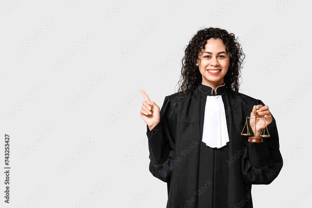 Beautiful young happy African-American female judge with scales of ...