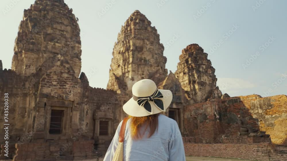 Back view of young asian woman tourist walking at Phra Prang Sam Yot ...