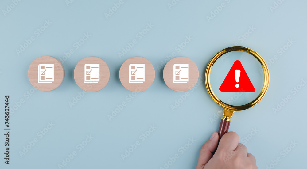 Man is holding magnifying glasses under the concept of warning alerts ...