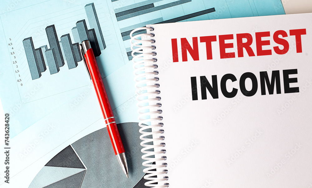 INTEREST INCOME text on a notebook with pen on a chart background Stock ...