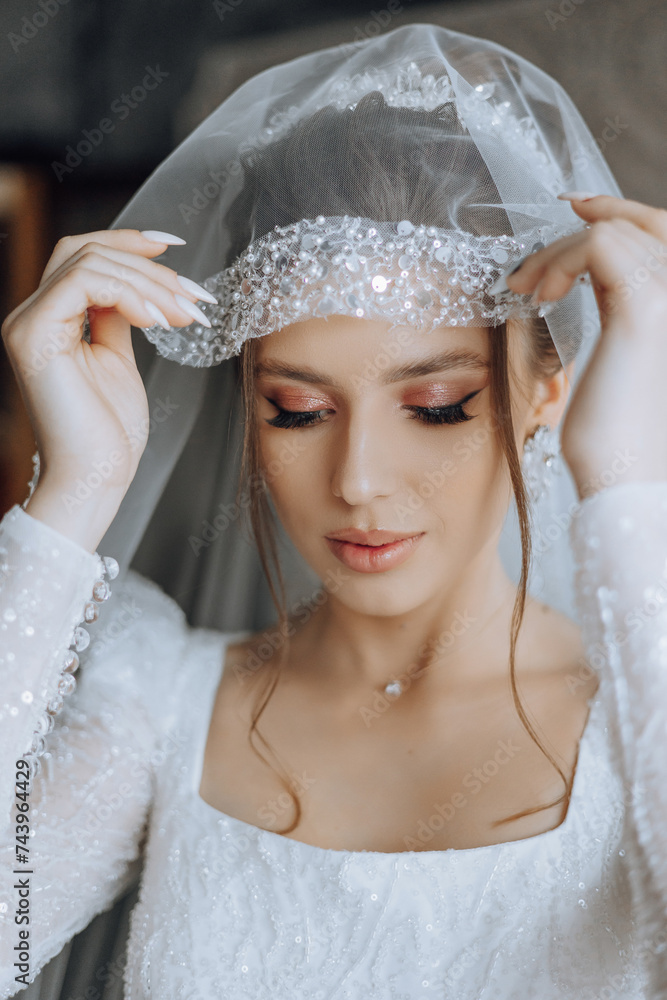 Beautiful young bride holding veil in white wedding dress, portrait of ...