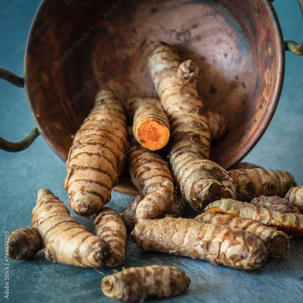 Turmeric roots close up view in a copper bowl Stock Photo | Adobe Stock