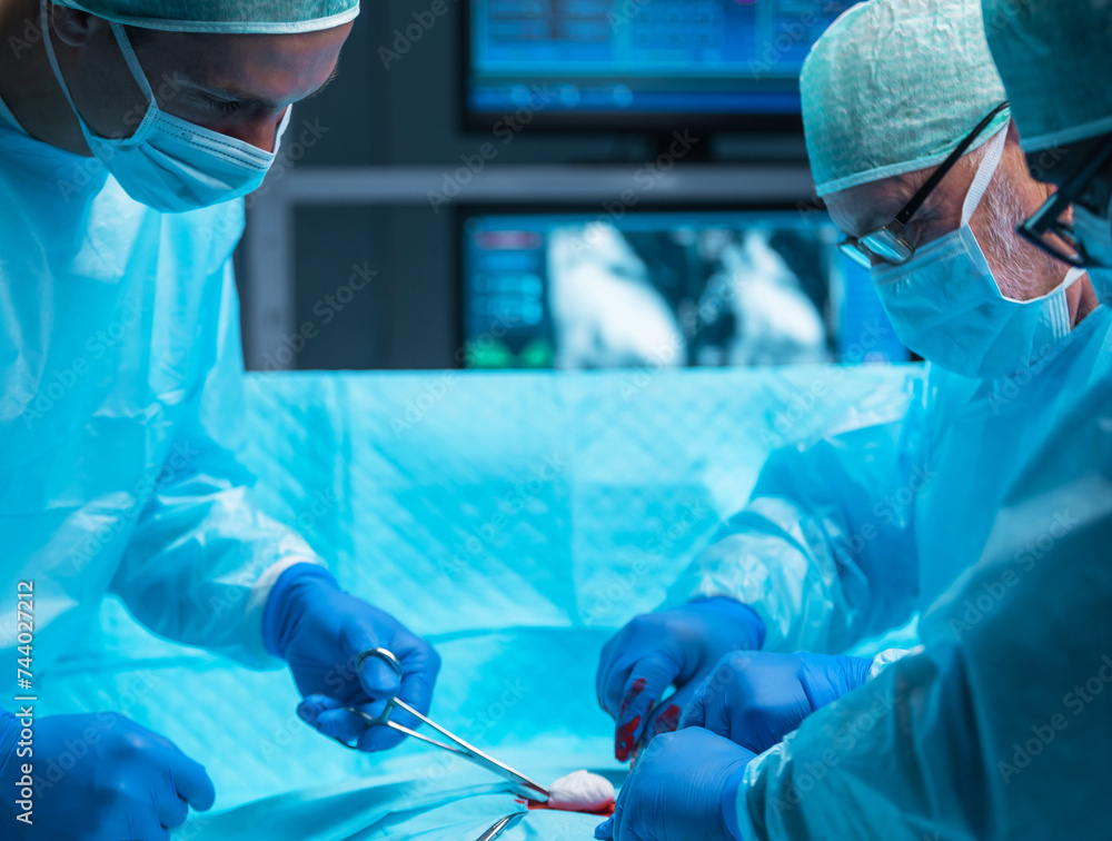 Team of medical doctors performs surgical operation in modern operating ...