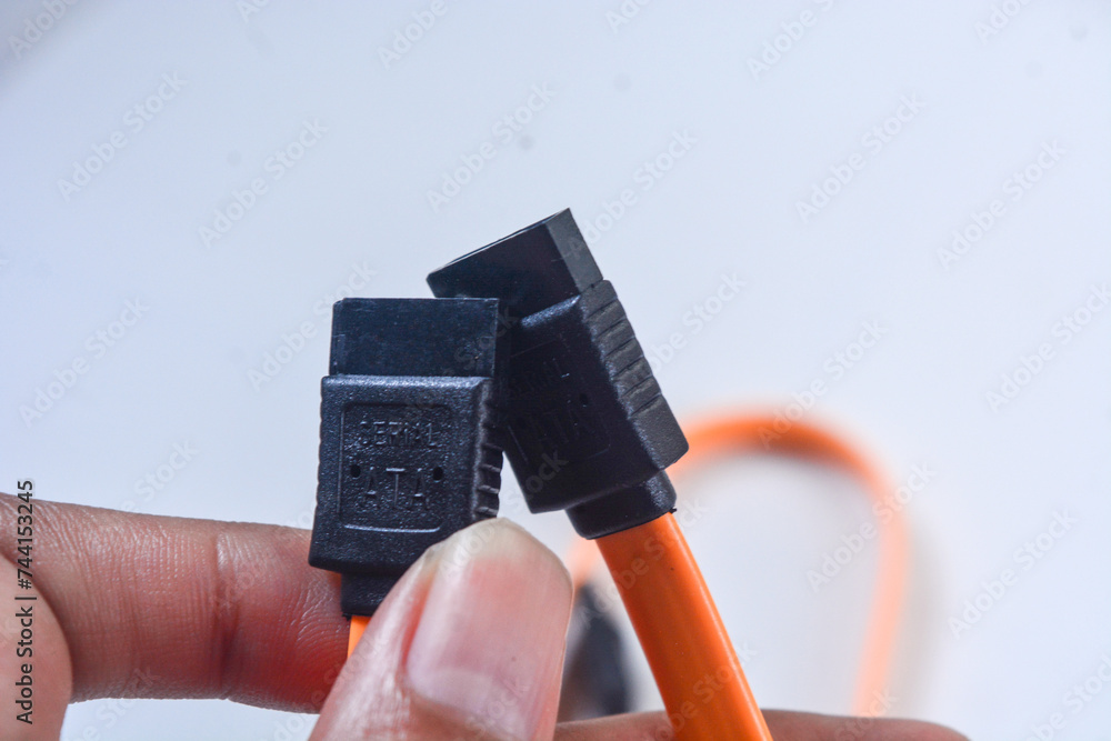 Close up orange Serial ATA(SATA) cable connected to computer ...