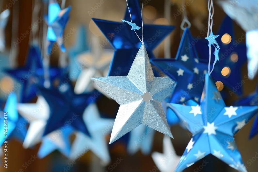 Multiple blue and white stars hanging from strings in a group, creating ...