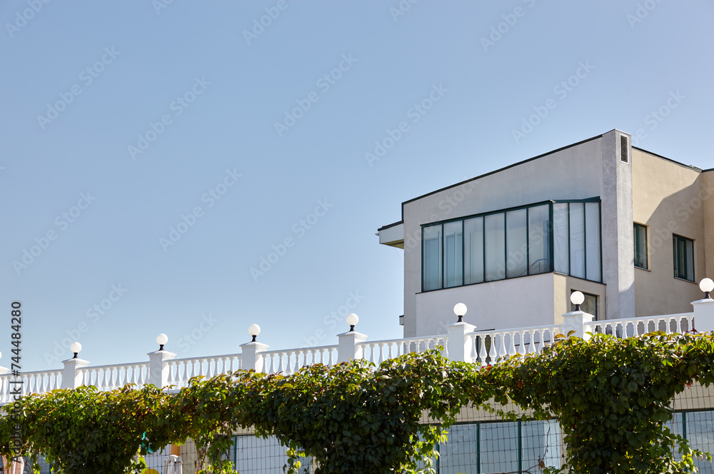 Fragment of the terrace with columns, lamps and railings. White stone ...