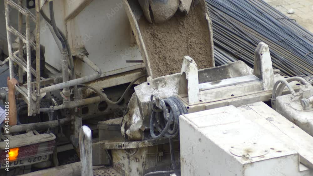Concrete being poured from truck into concrete pump at the construction ...